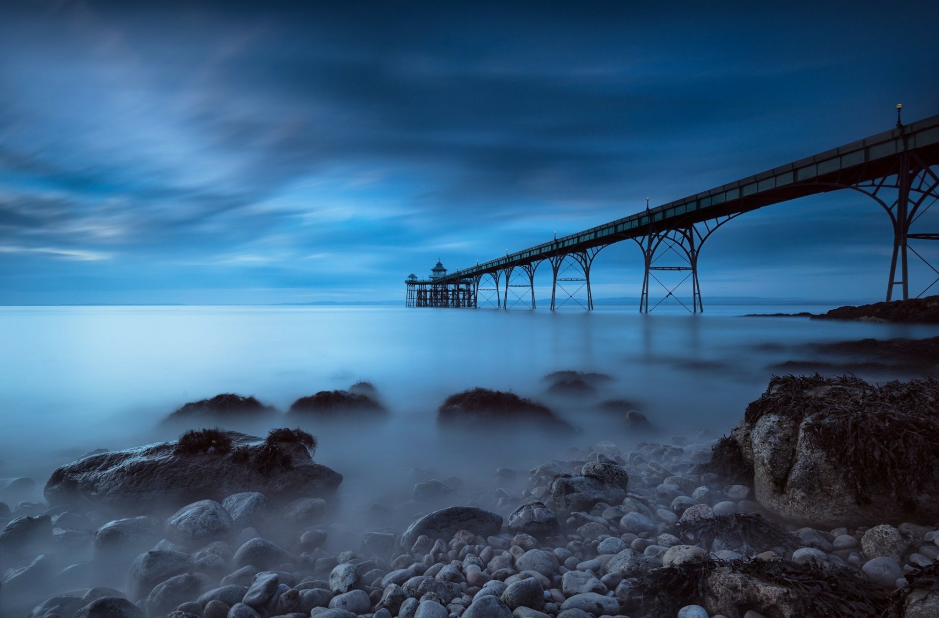 Misty Pebble Shoreline with Pier HD Wallpaper