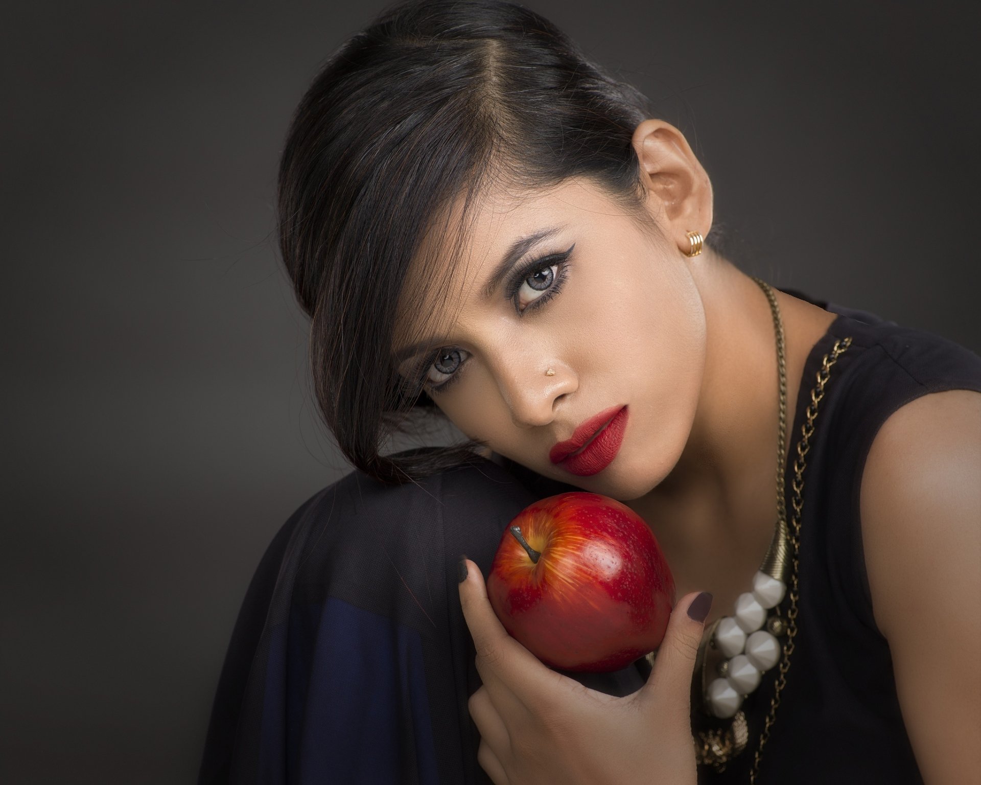 Enchanting Brunette Model with Blue Eyes and Scarlet Lips Holding a ...