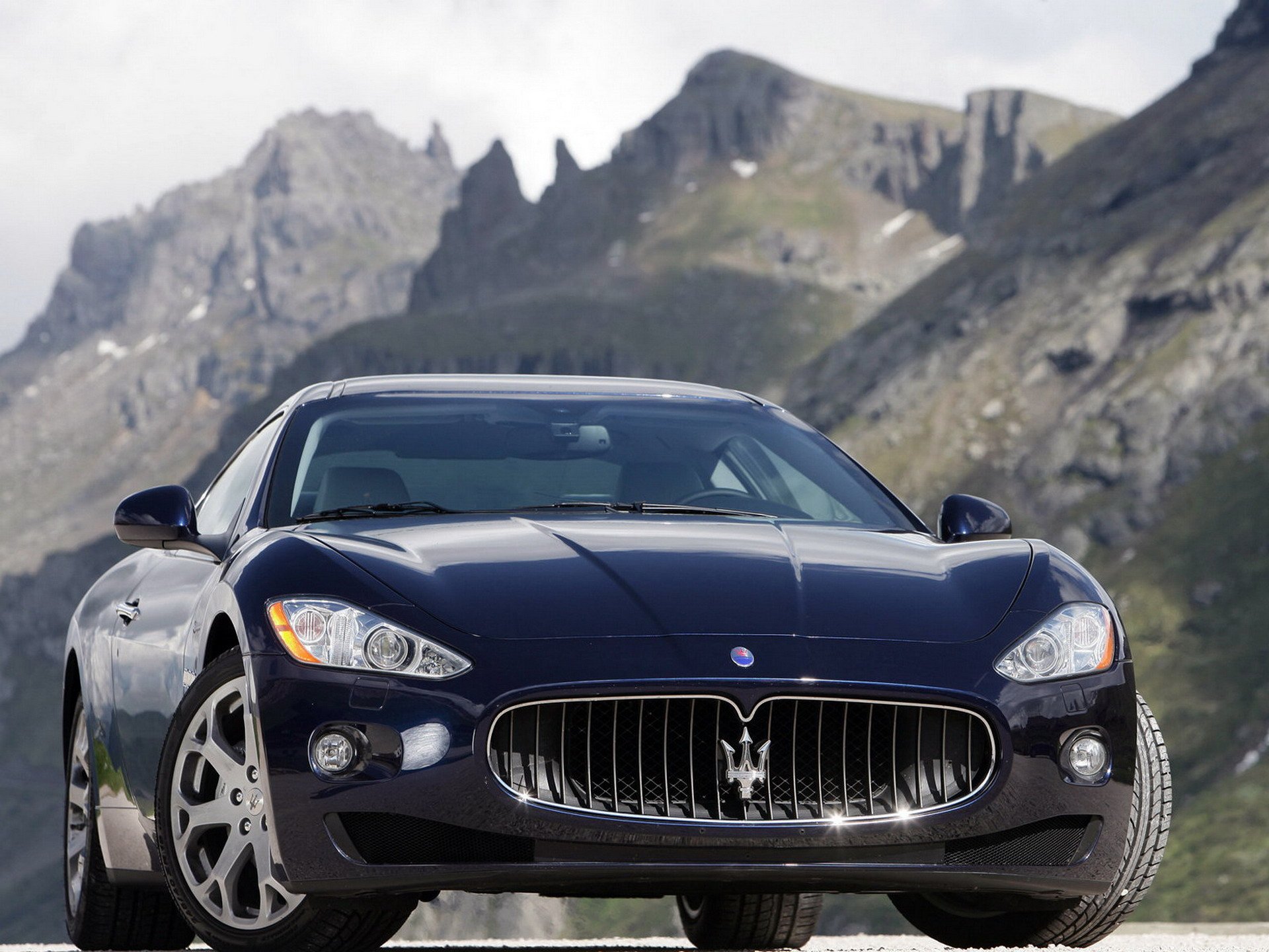 Maserati Majesty: HD Wallpaper of a Sleek Luxury Car in Mountain Terrain